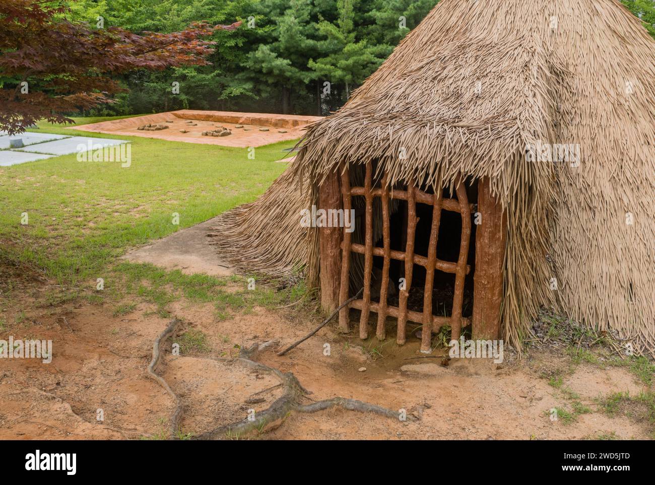 Closeup front view of straw thatched hut at prehistoric archeological ...