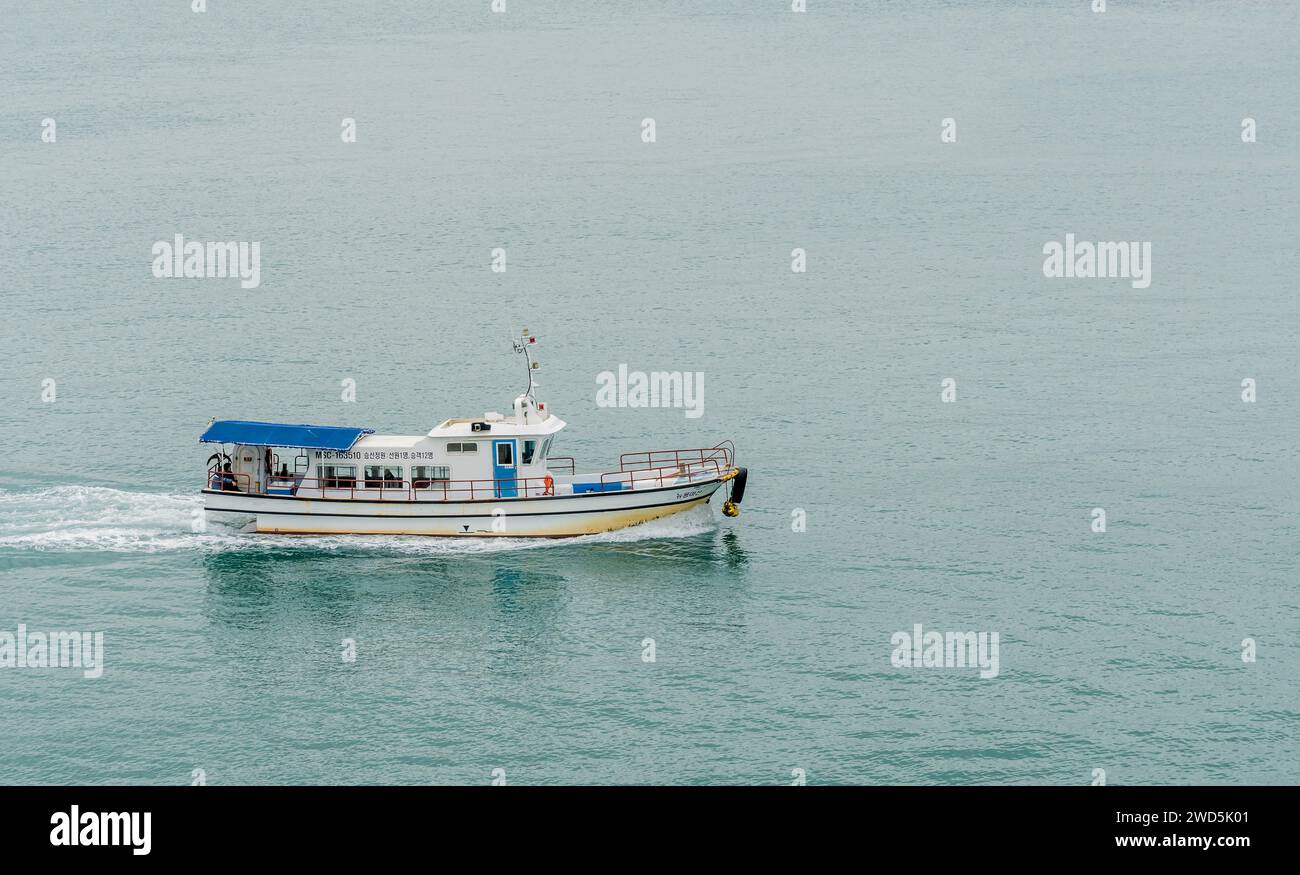 Small ferry boat making its way across ocean harbor waters, South Korea ...