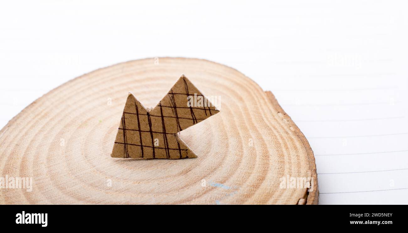 Arrow sign cut out of brown paper on piece of wood Stock Photo - Alamy