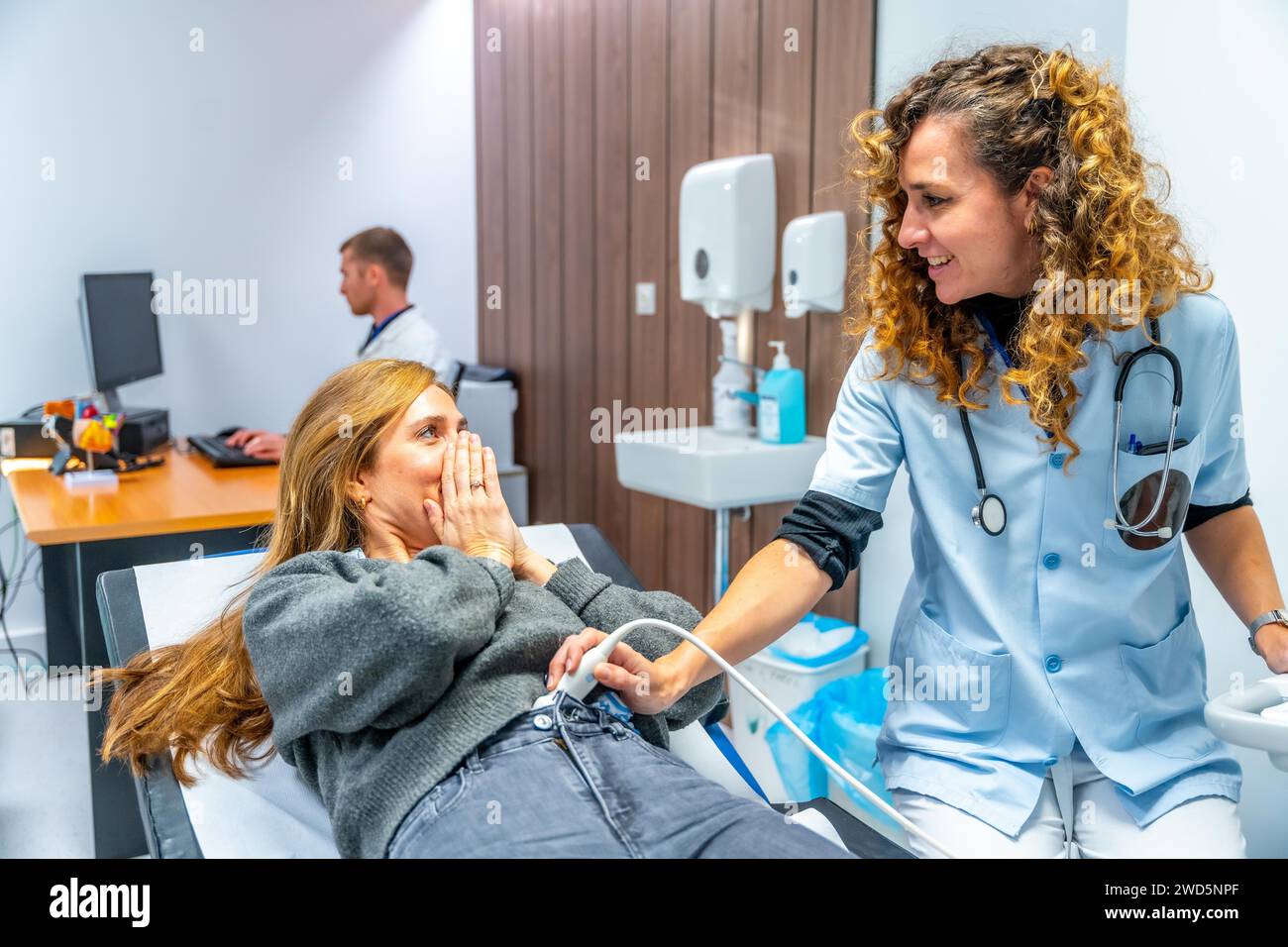 Female doctor informing a patient that she is pregnant during an ...