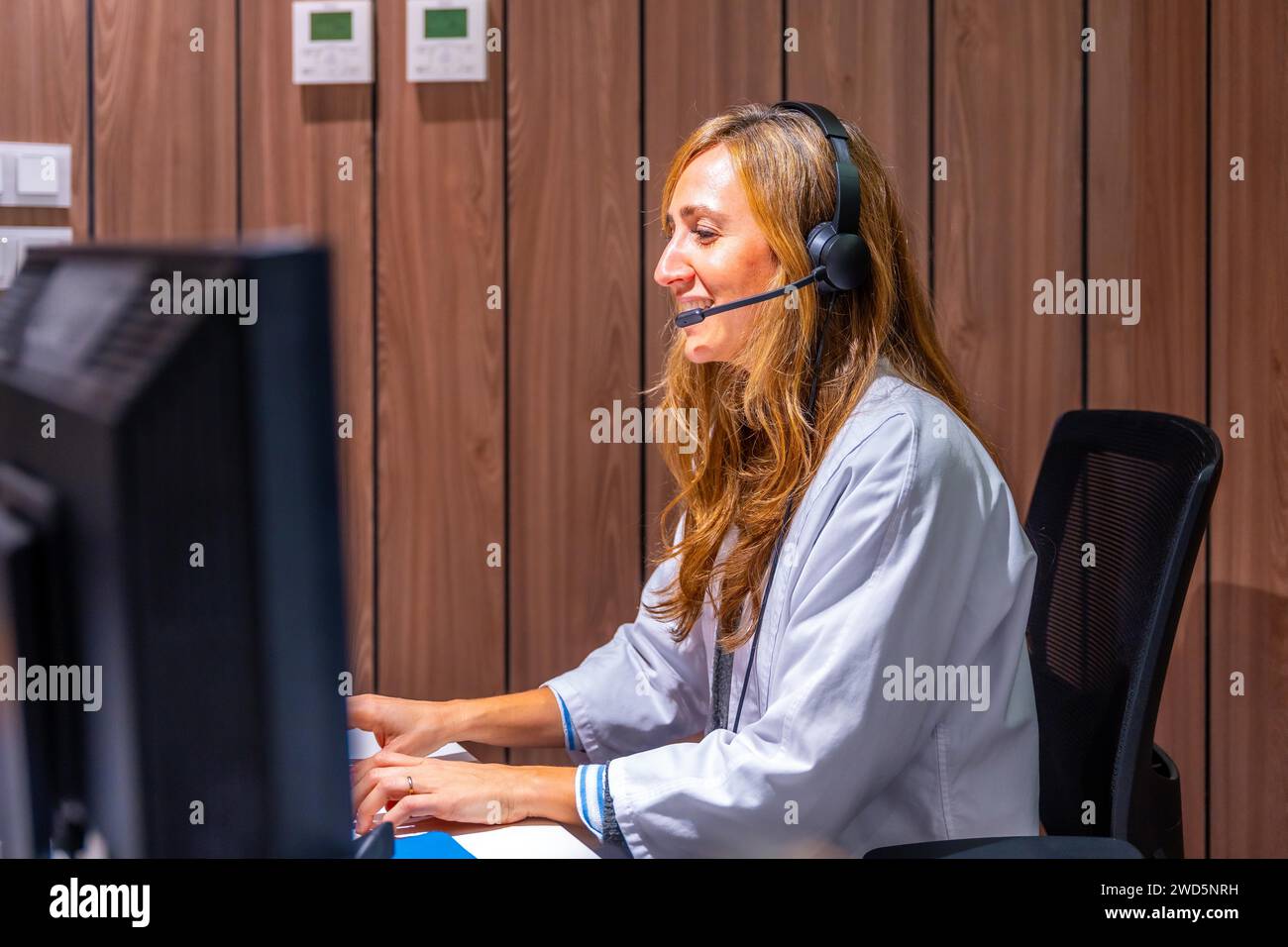 Hospital nurse receptionist talking to patient at registration counter ...