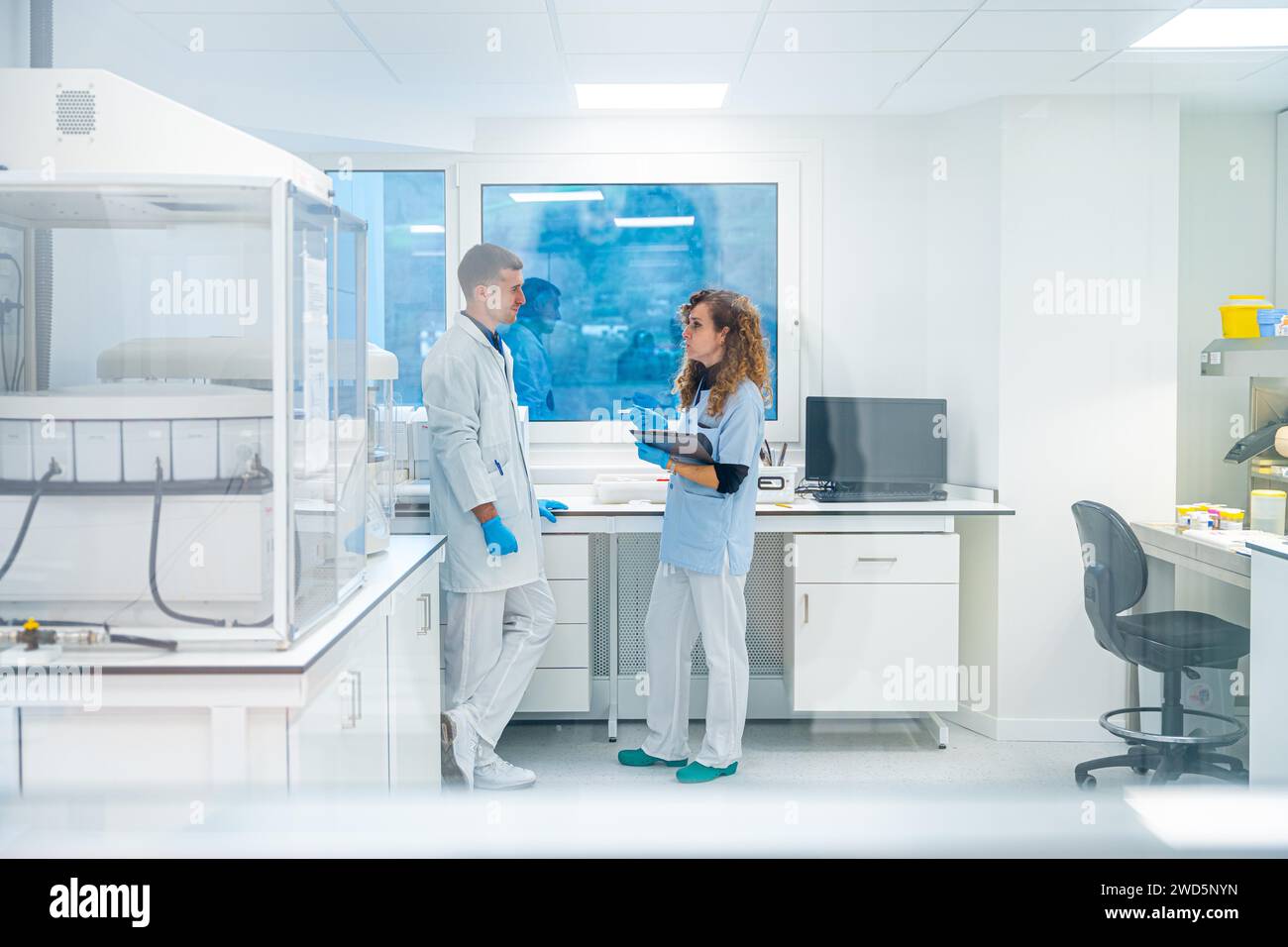 Wide view of medical team talking and working in the laboratory of an ...