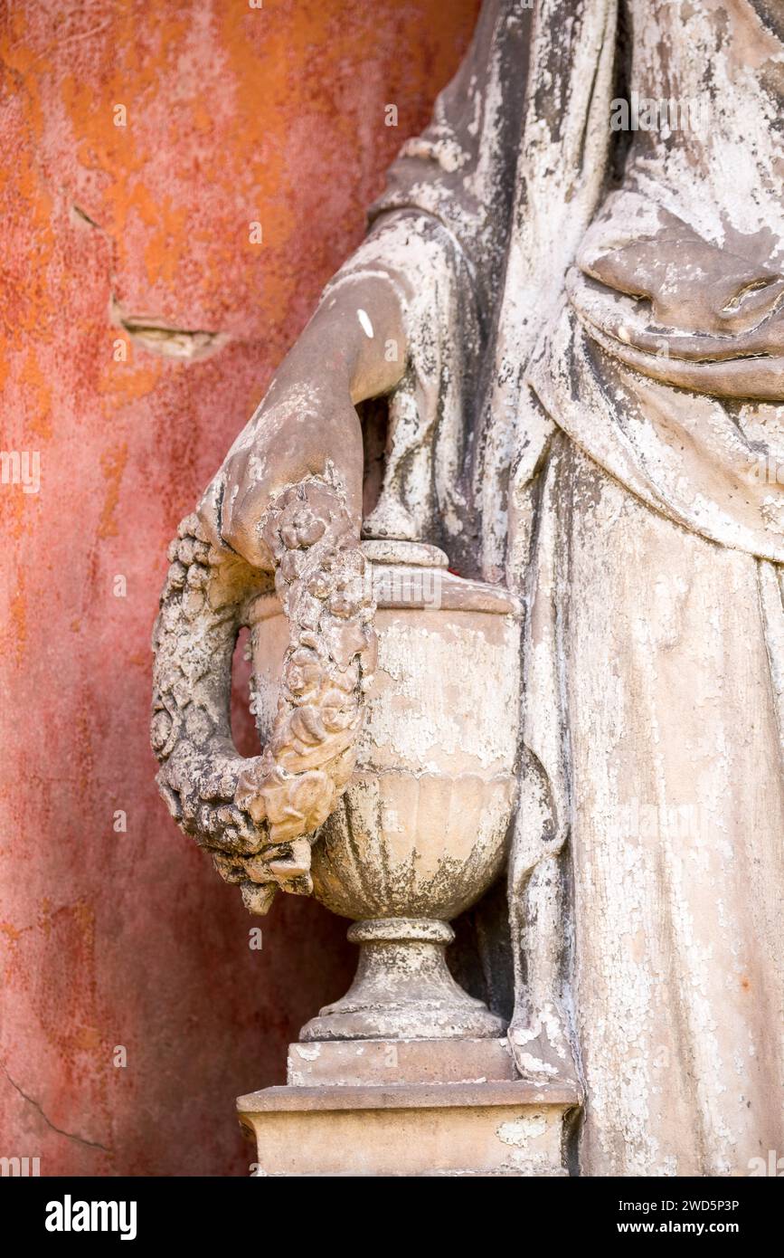 White angel, hand holding a wreath of flowers on an urn, detail of a ...
