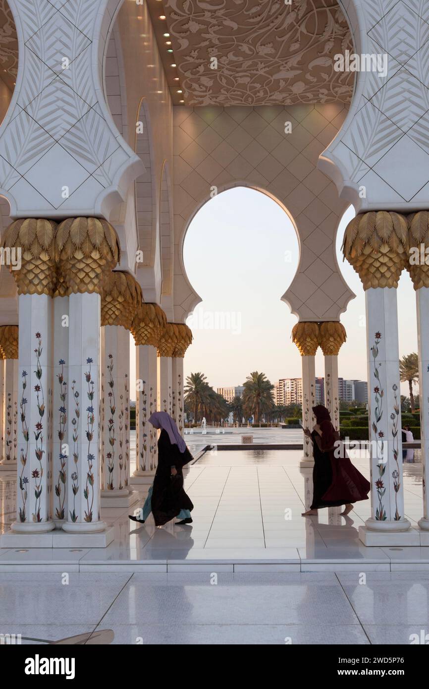 Two muslim women walk by the corridors near the courtyard, Abu Dhabi ...