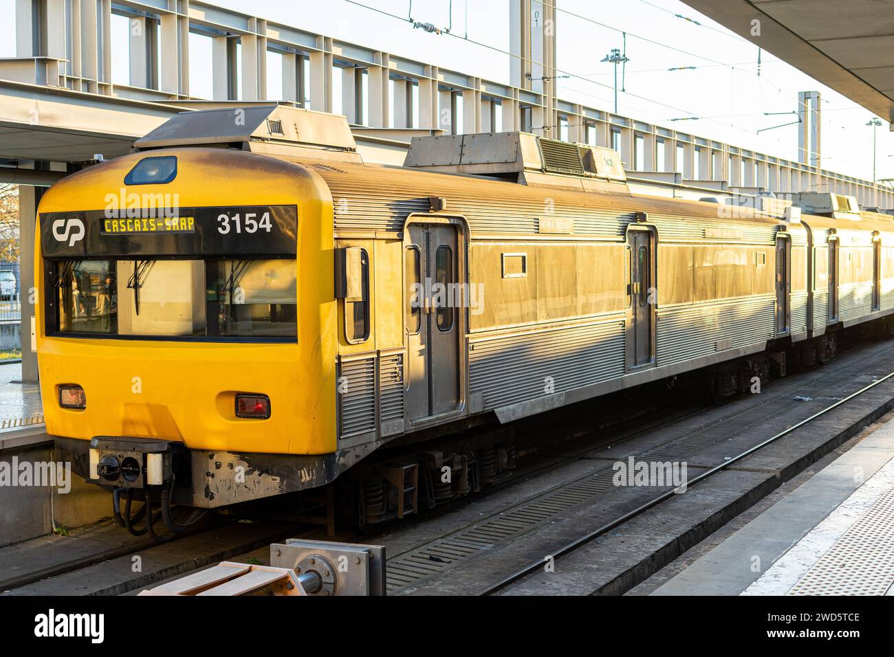 Yellow public transport train bound for Cais do Sodré stopped at Cais ...