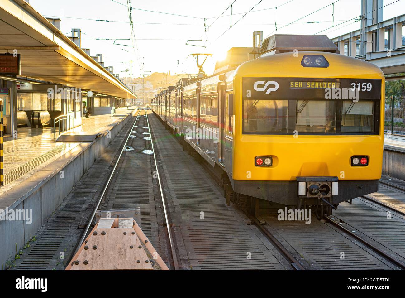 Yellow public transport train bound for Cais do Sodré stopped at Cais do Sodré train station in ...