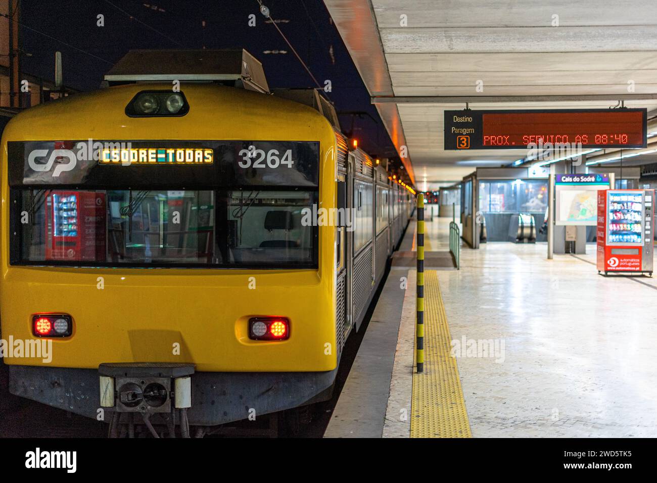 Yellow public transport train bound for Cais do Sodré stopped at Cais do Sodré train station in ...