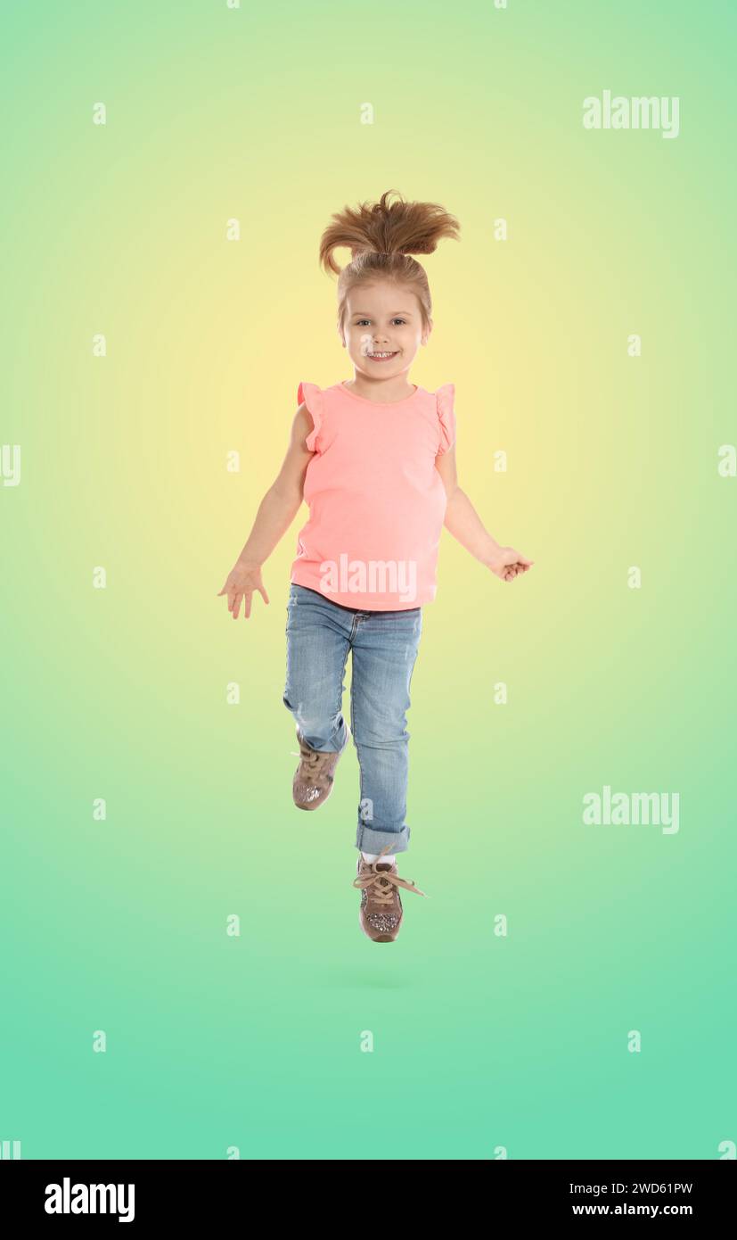Happy cute girl jumping on color gradient background Stock Photo - Alamy