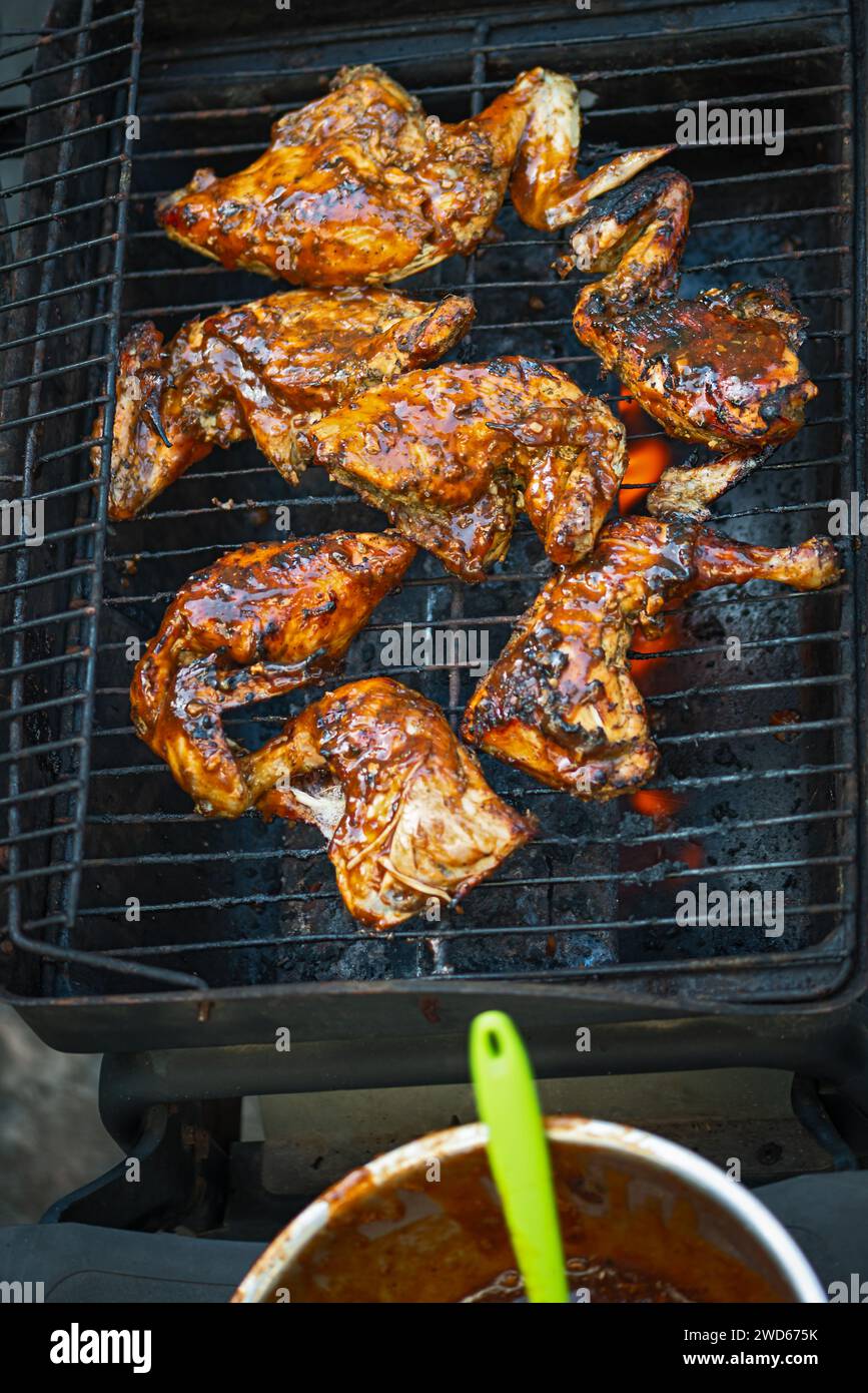 Barbeque pit chicken leg and thigh covered in BBQ sauce and spices ...