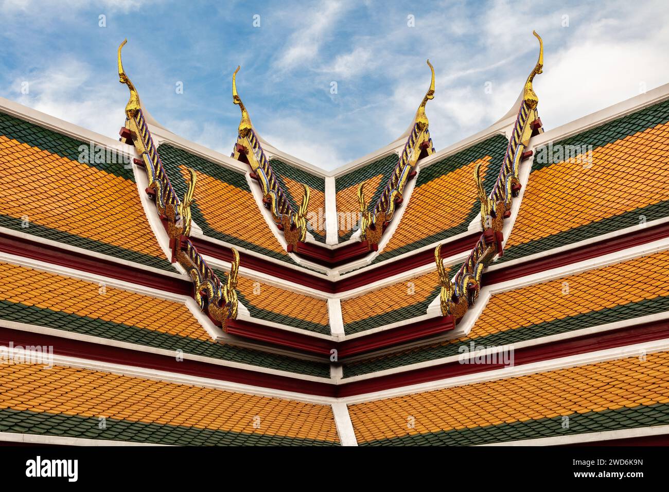 Decorated roof at Wat Suthat in Bangkok, Thailand. Design of orange, red and green tiles, golden ...