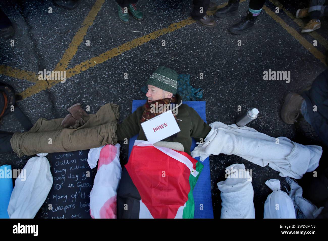 An activist lies down on the freezing ground connected to colleagues ...