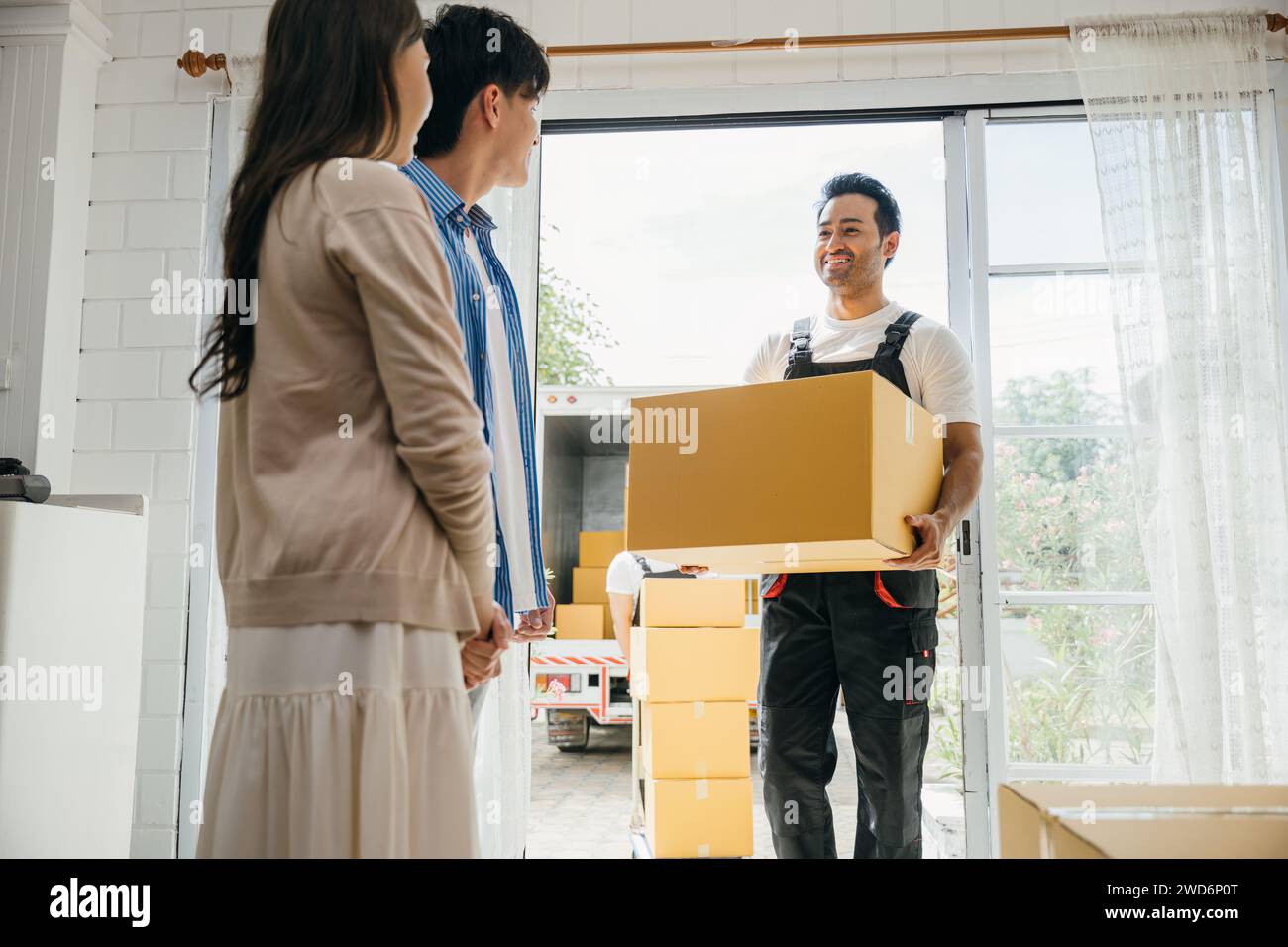 Inside the home a couple receives efficient moving service. Uniformed ...