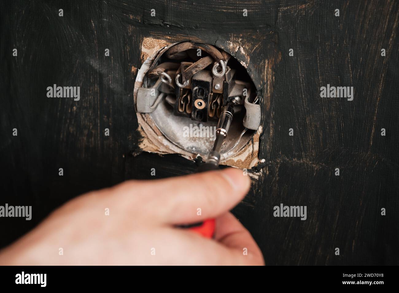 male electrician repairs an old electrical outlet. Replacement and ...