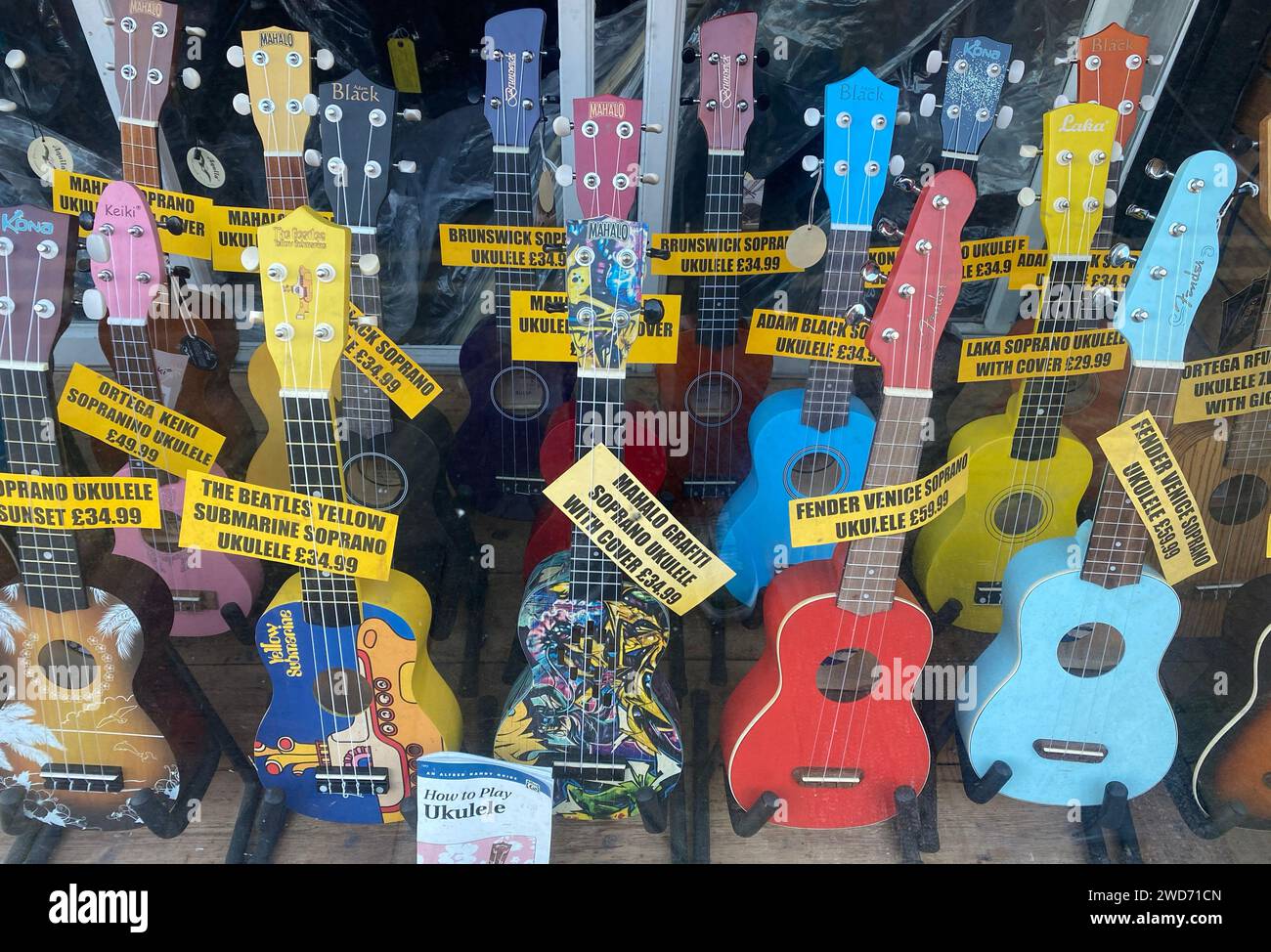 A musical instrument shop window displaying lots of Ukulele’s for sale ...