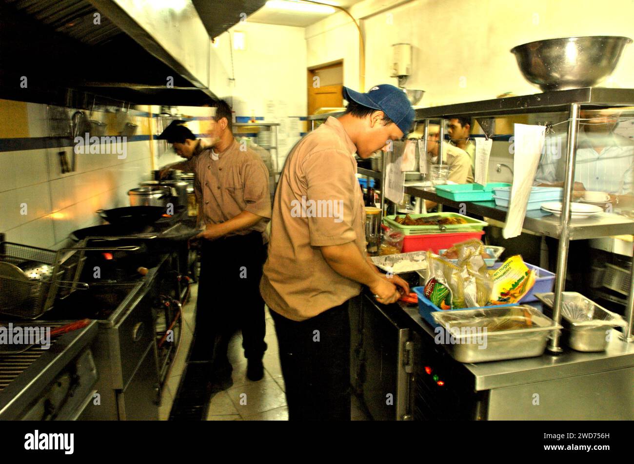 Chefs prepare halal foods at the kitchen of an Islamic cafe managed by ...