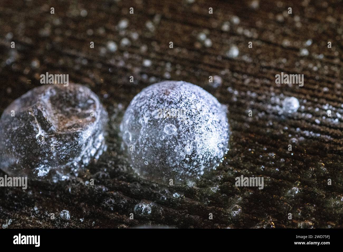 Half a frozen bubbles sitting on a frosted covered surface, with one ...