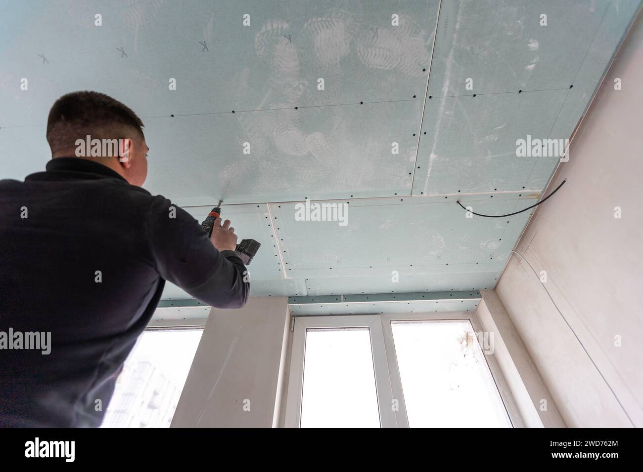 Construction worker installation ceiling work Stock Photo - Alamy