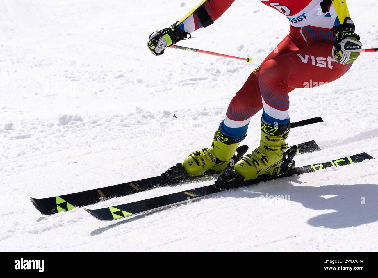 Crop closeup view of mountain skier sports person skiing down an alpine ...
