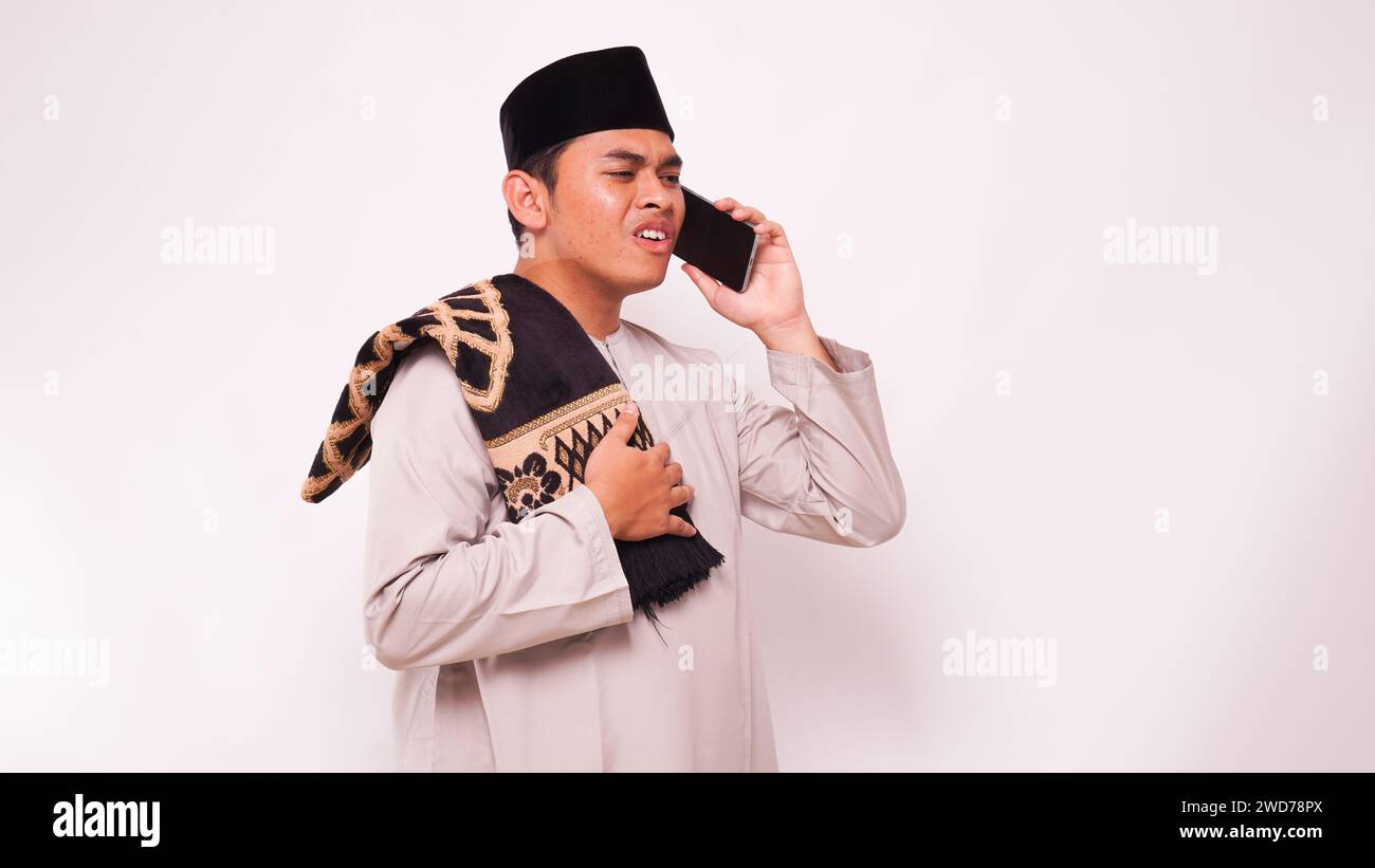 Asian muslim man make a phone call during eid celebration. isolated on ...