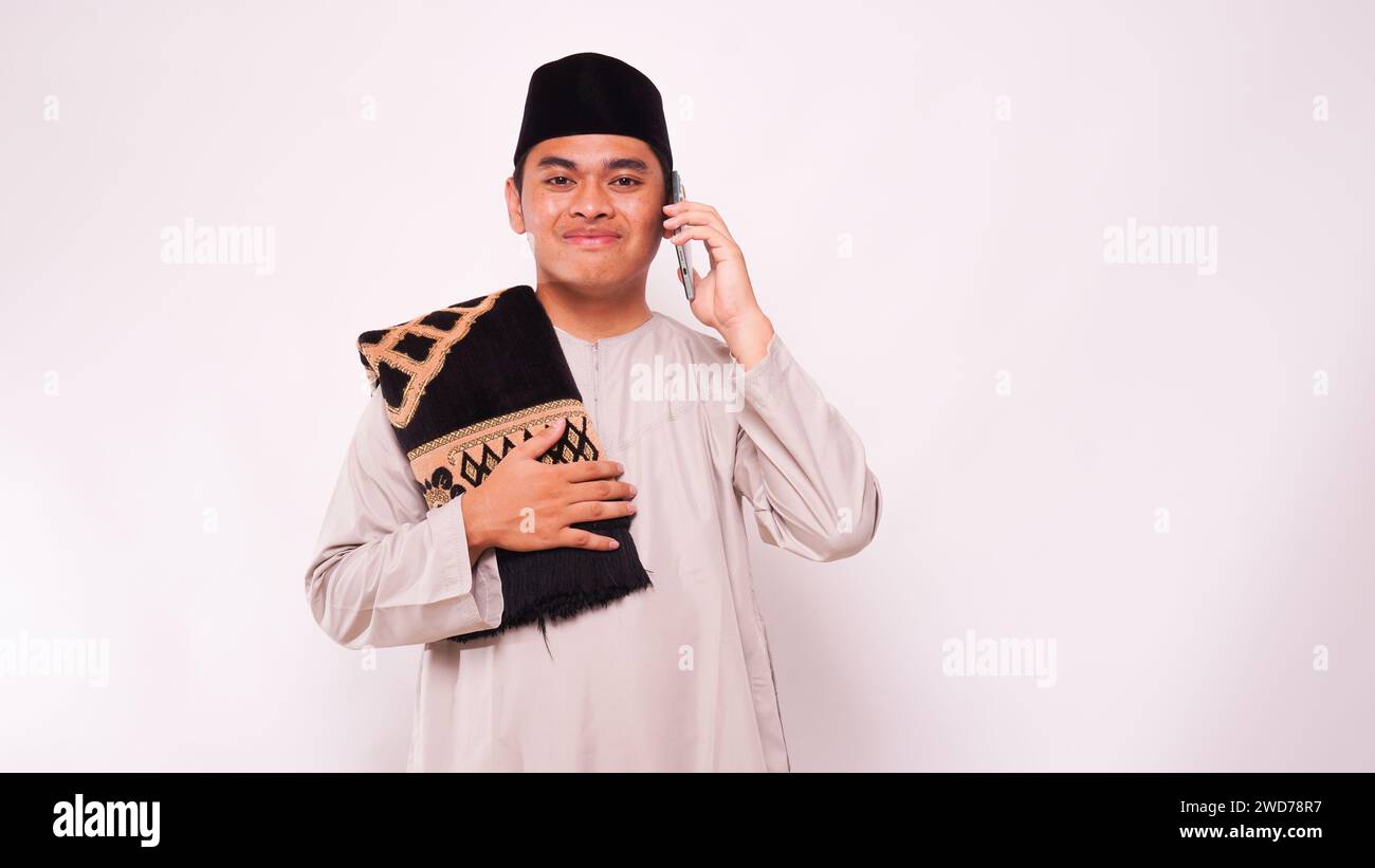 Asian muslim man make a phone call during eid celebration. isolated on ...