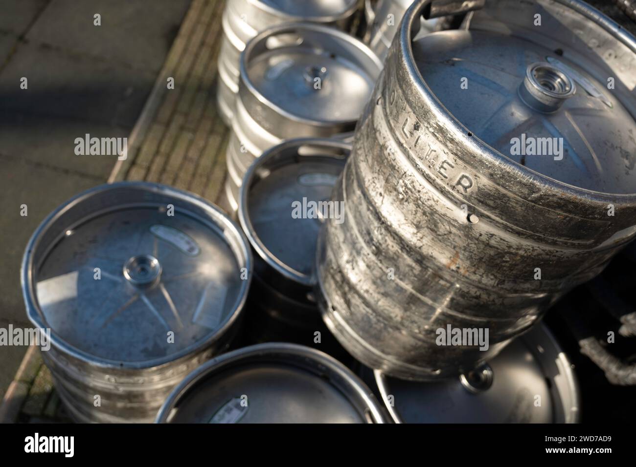 Large damaged 50 liter metal beer barrels stand on the terrace of a ...
