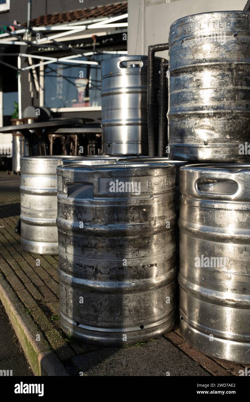 Stacked large 50 liter metal beer barrels on the terrace of a café ...