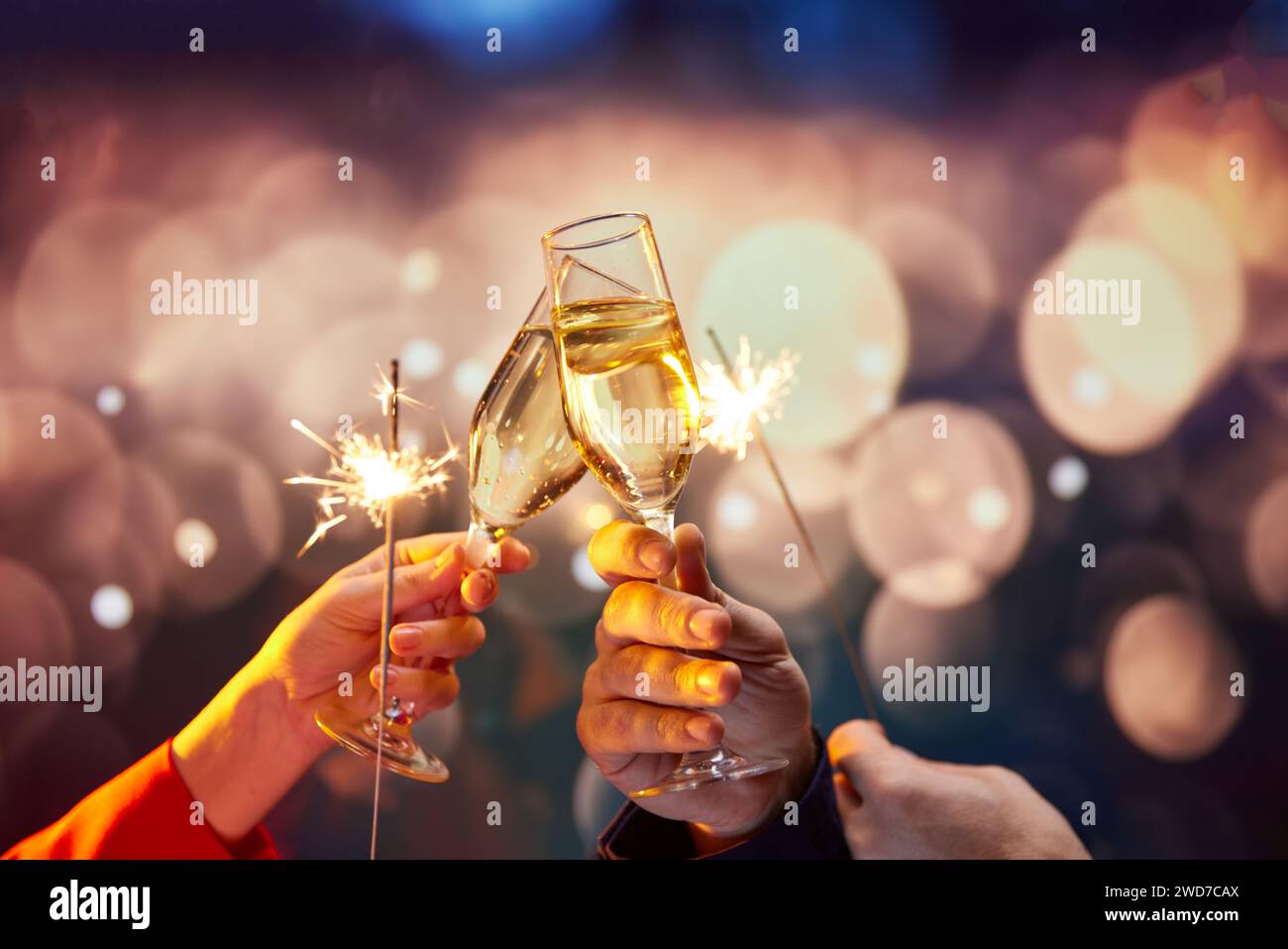 Romantic date night experience service, complete with champagne and sparklers. Two hands holding ...