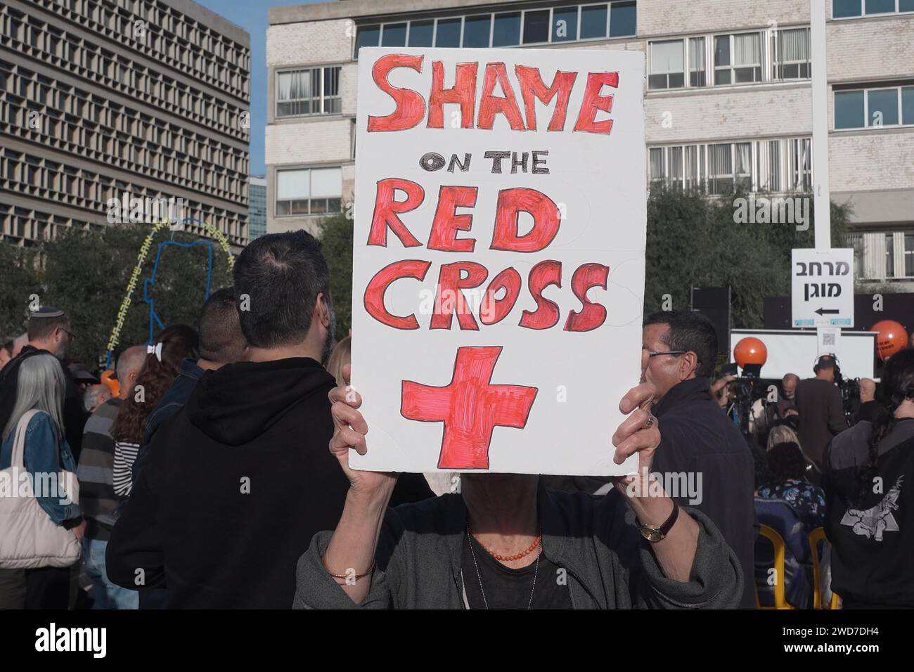 A woman holds a sign that reads' Shame on the red cross" as Israelis ...