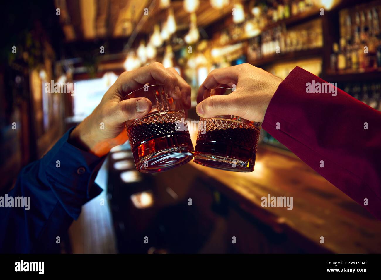 Male hands, businessmen clinking whiskey glasses, meeting at pub ...