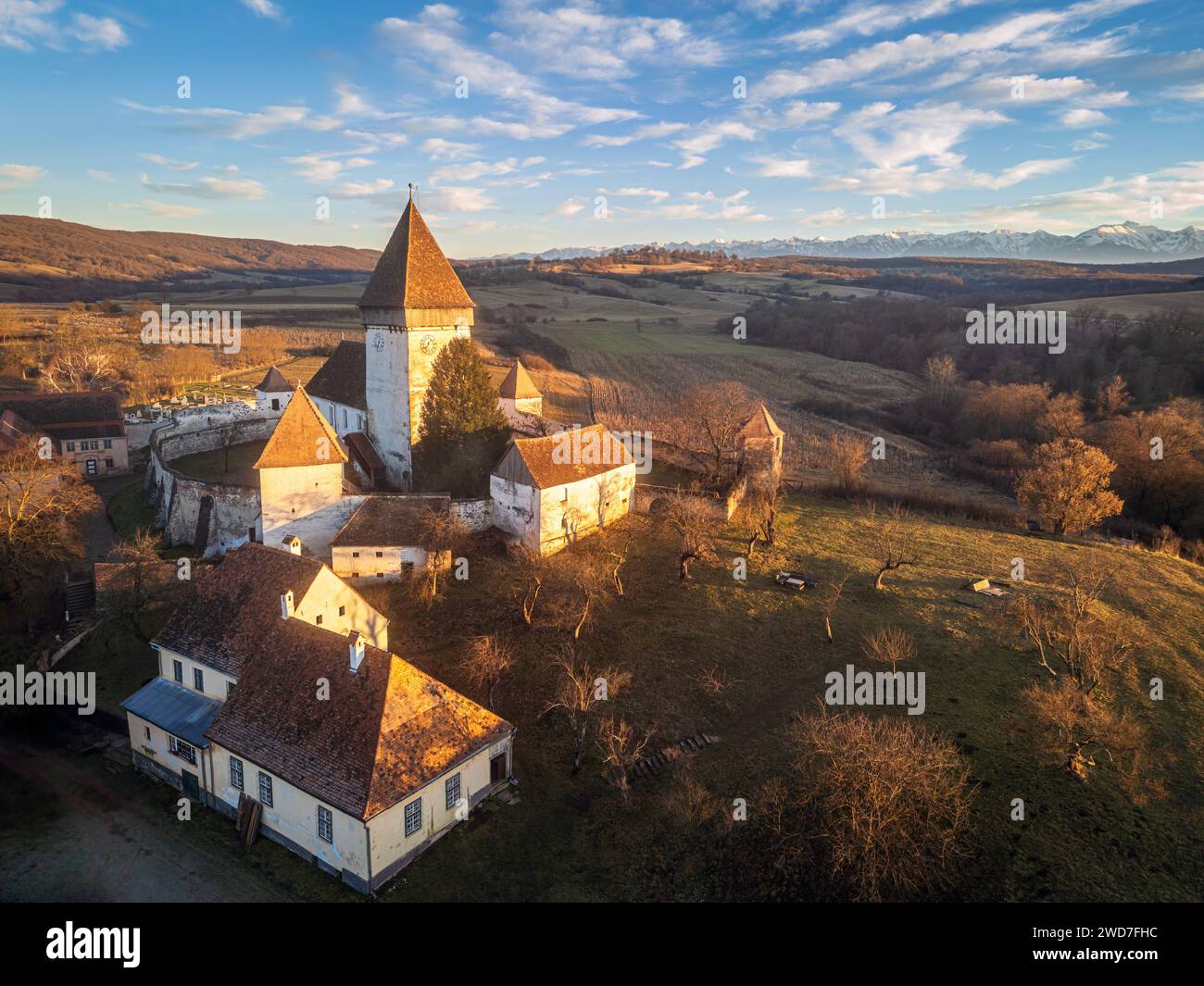 The fortified church of Hosman at sunset golden hour. Drone photo taken ...