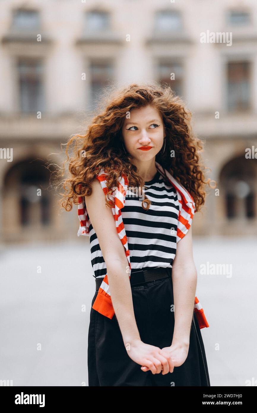 Curly redhead young woman in Prague, cloudy Stock Photo - Alamy