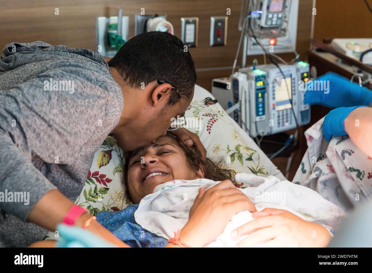 Multiracial couple kissing after giving birth in hospital Stock Photo ...