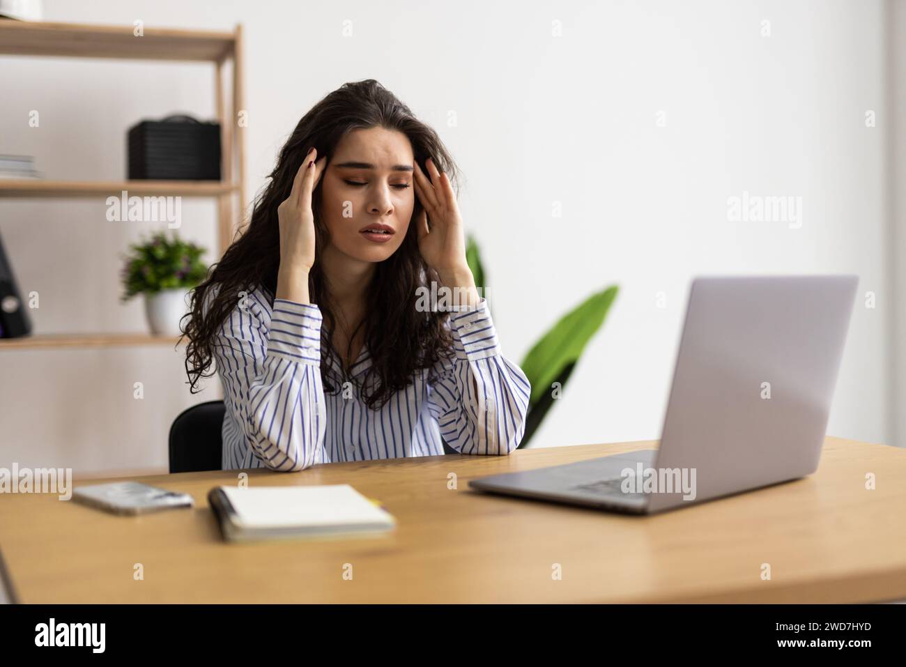 Young attractive woman at modern office desk, working on laptop ...