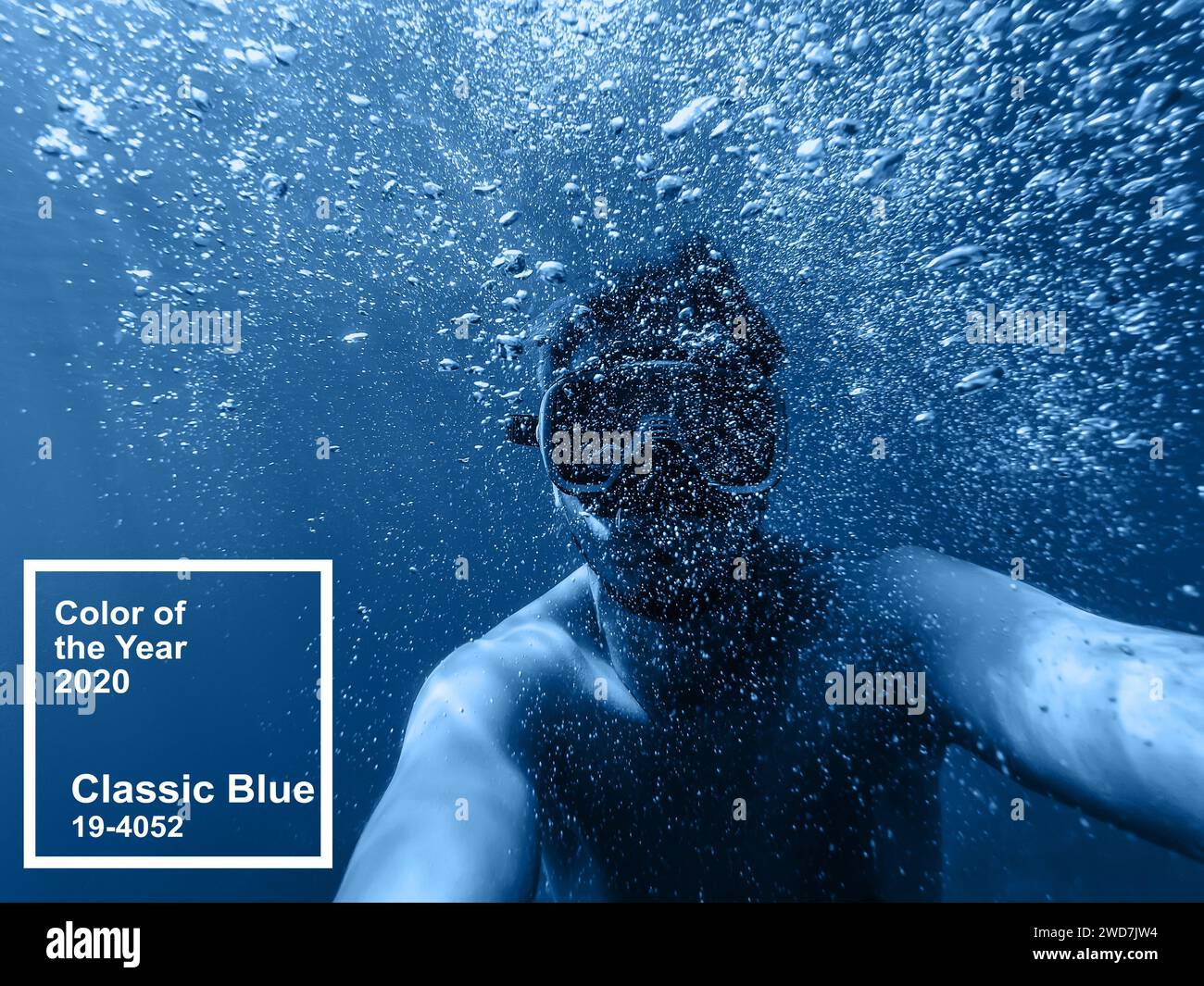 male diver swims in the sea under water with a mask and snorkel is ...