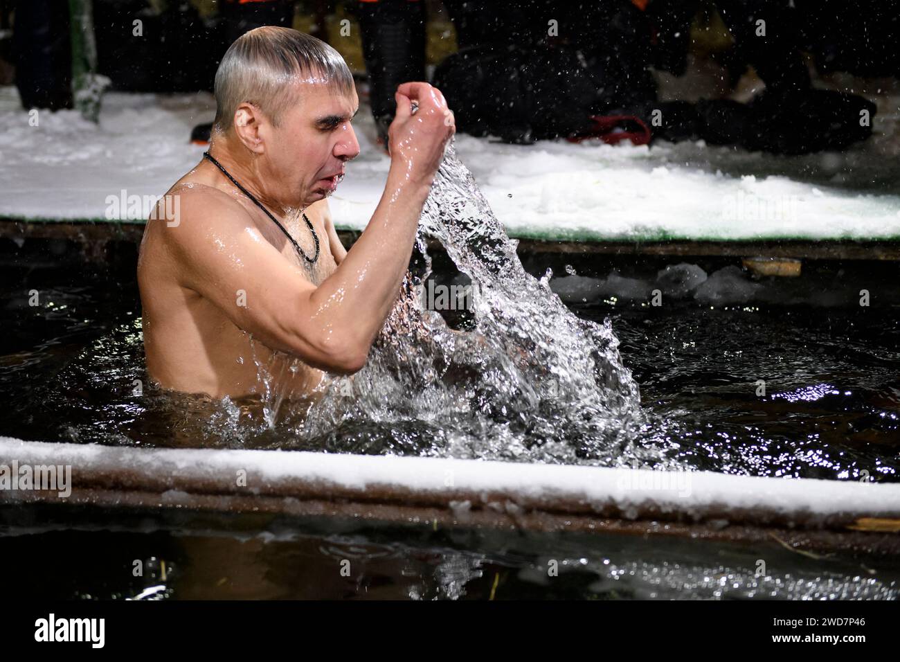 Moscow, Russia. 18th Jan, 2024. A man takes a dip in the icy water ...