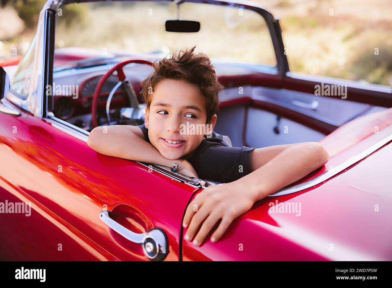 Young boy sitting in red classic car smiling Stock Photo - Alamy