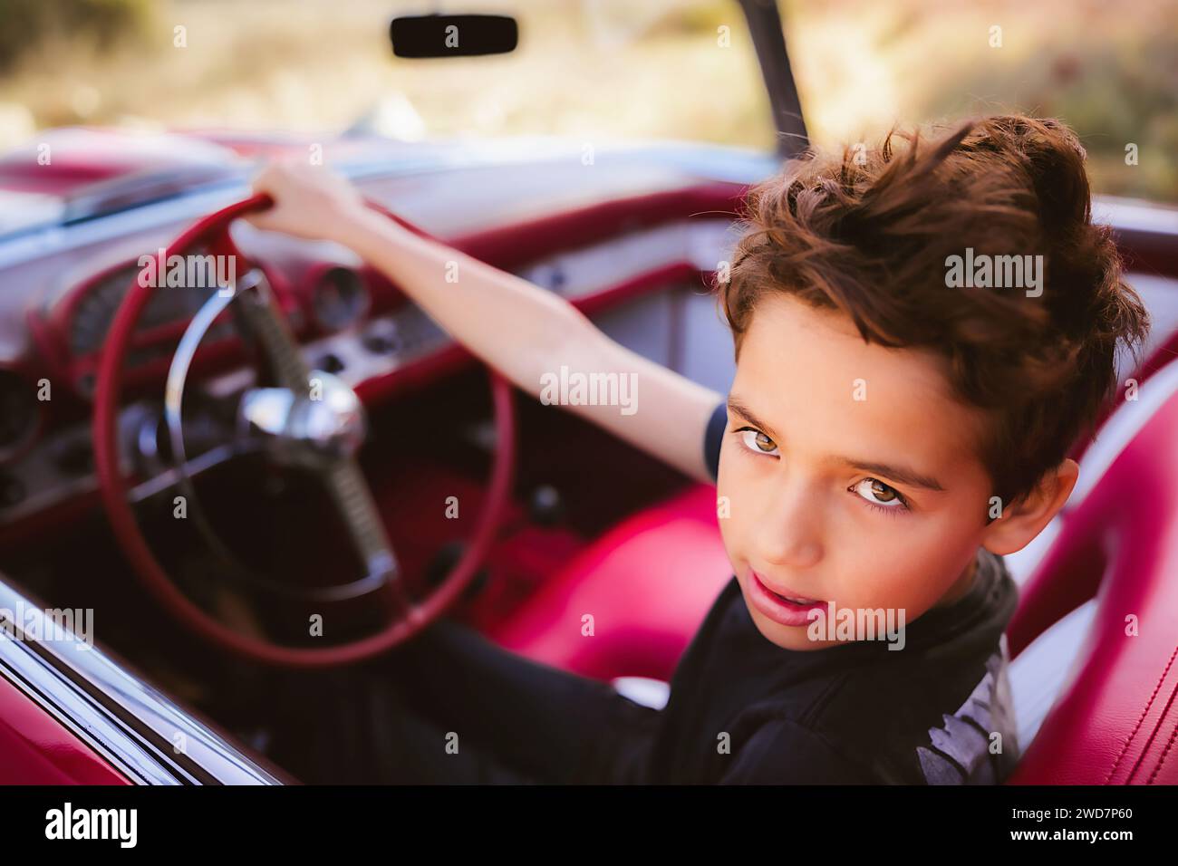 Young boy sitting in red classic car pretending driving Stock Photo - Alamy