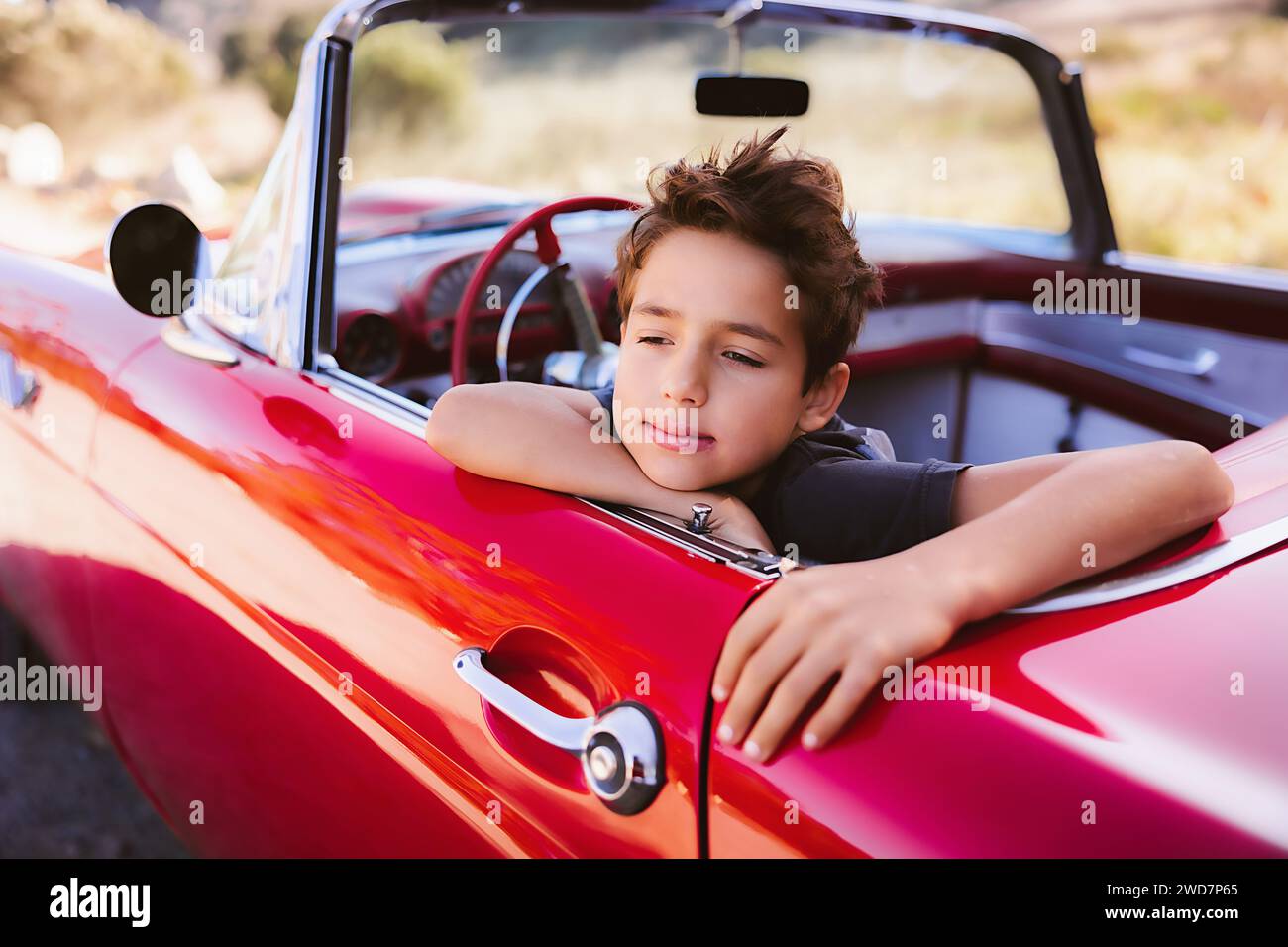 Young boy sitting in red classic car day dreaming Stock Photo - Alamy