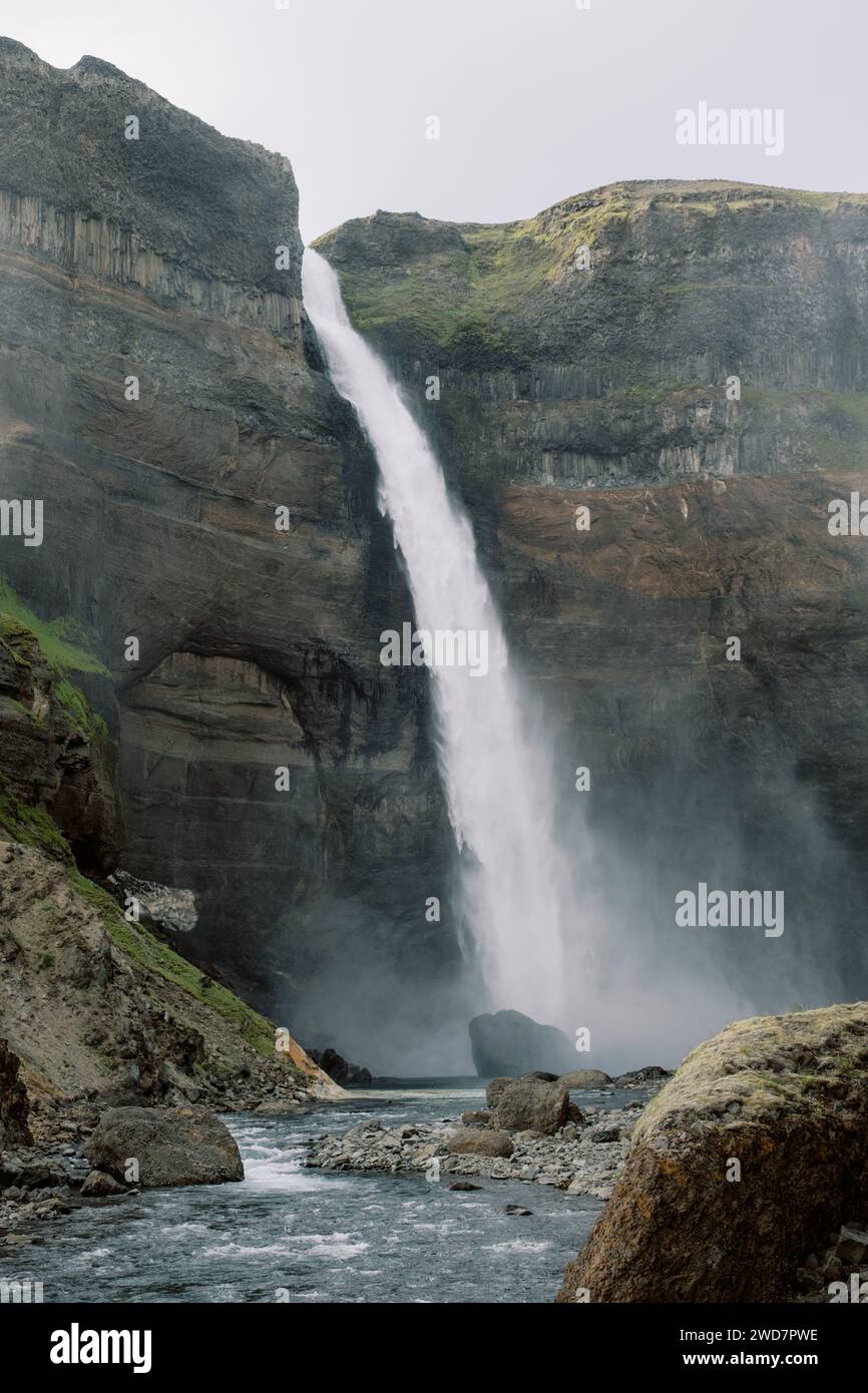 Full view of Iceland Granni waterfall descending into coursing river ...