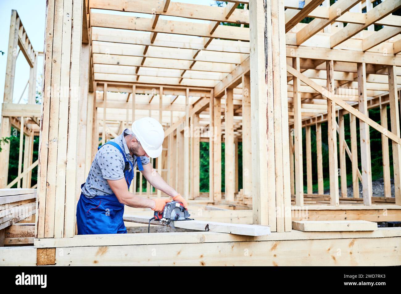 Carpenter using circular saw for cutting wooden plank. Man worker ...