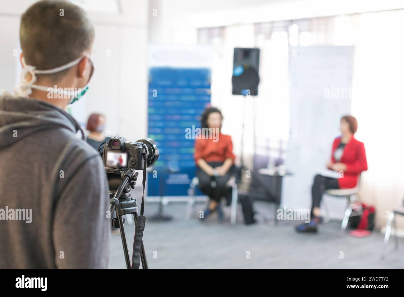 cameraman with face mask recording video at debate event Stock Photo ...