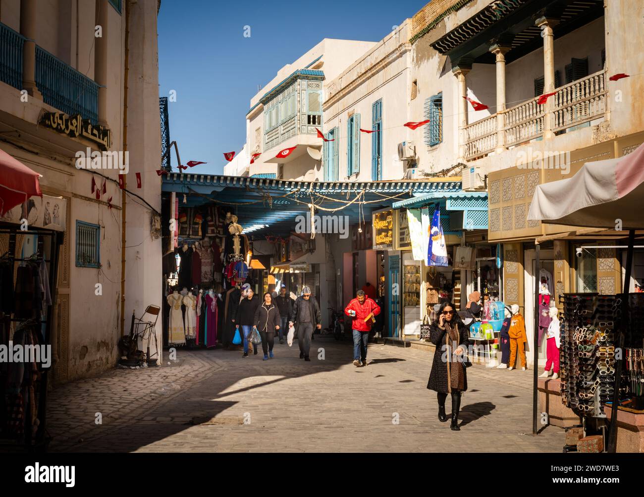 People walk out from the souk within the ancient medina of Kairouan ...
