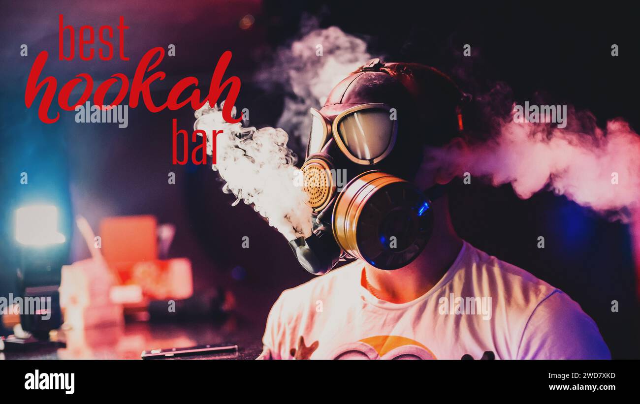 man in a gas mask smokes a hookah and lets out a lot of smoke. Concept ...