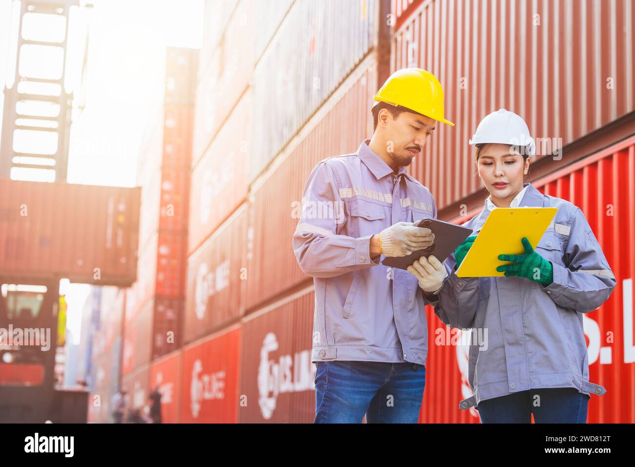 Asian man and women team workers customs staff teamwork in container yard port shipping cargo ...