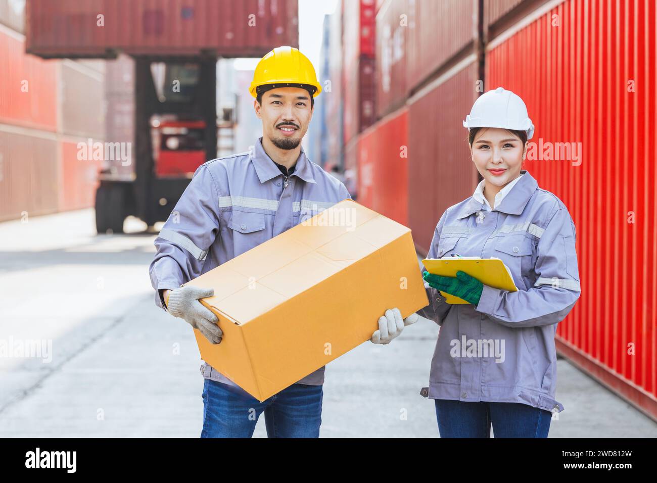 Asian man and women team workers customs staff teamwork in container yard port shipping cargo ...