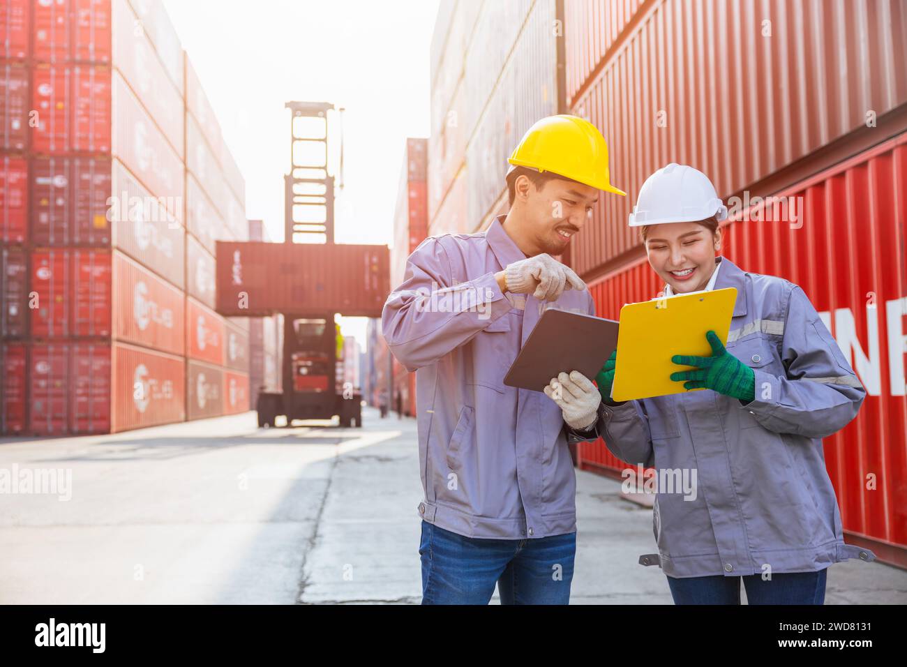 Asian man and women team workers customs staff teamwork in container yard port shipping cargo ...