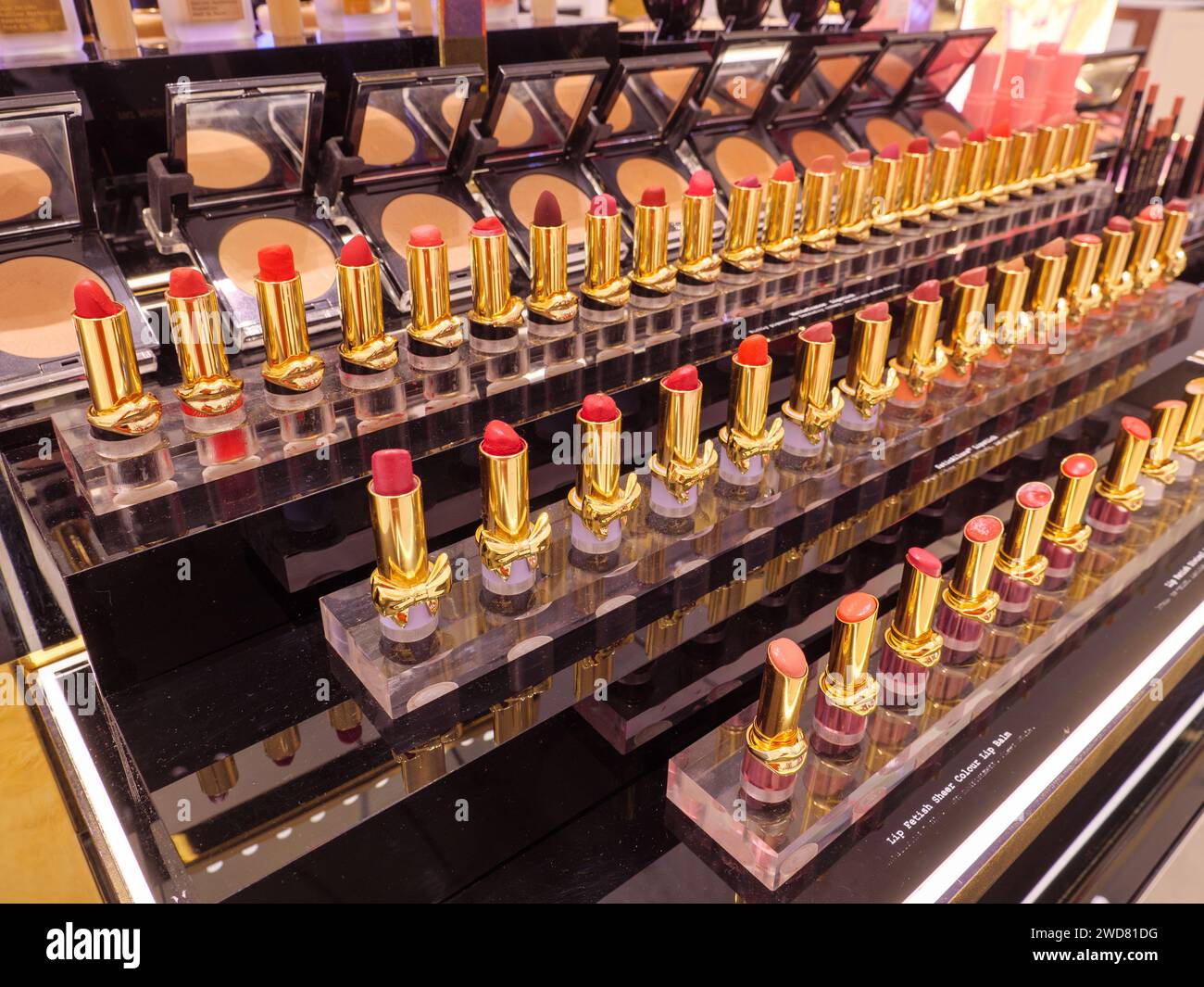 Rows of shades of red lipstick makeup on the cosmetics counter of a ...