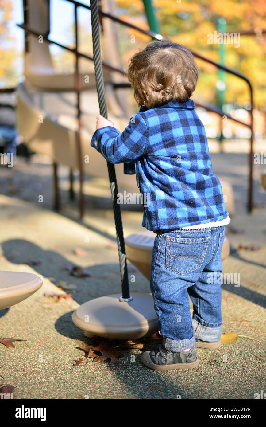 Toddler learning to walk in playground Stock Photo - Alamy