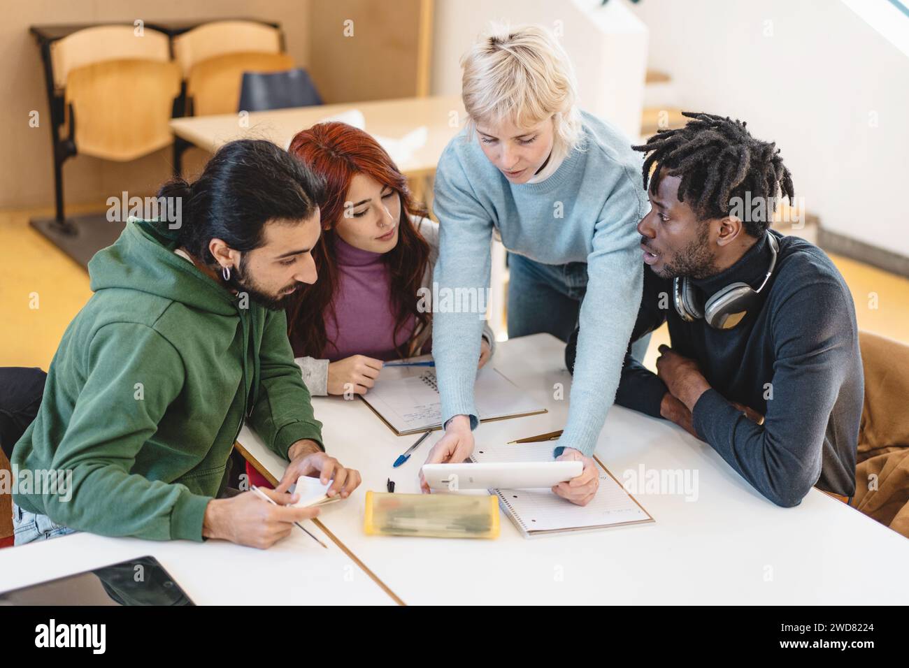 Diverse group of students engaging in a focused group discussion over coursework, highlighting ...