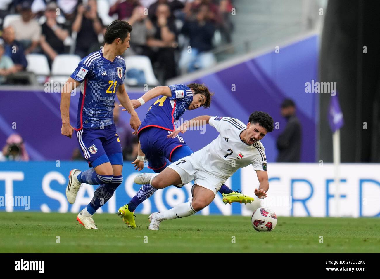 Iraq's Youssef Wali Amyn, right, is stopped by Japan's Junya Ito ...